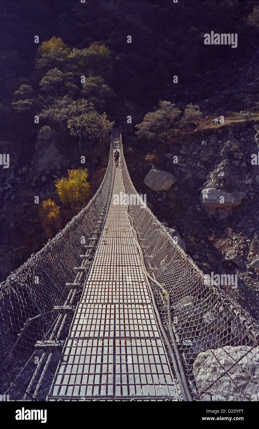 Trekkers crossing wire rope suspension bridge over Kali Gandaki river ...