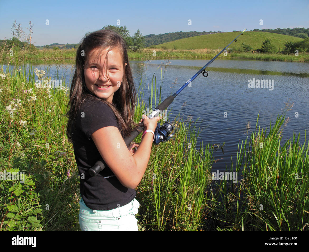 Young girl angler fishing on canal Stock Photo - Alamy