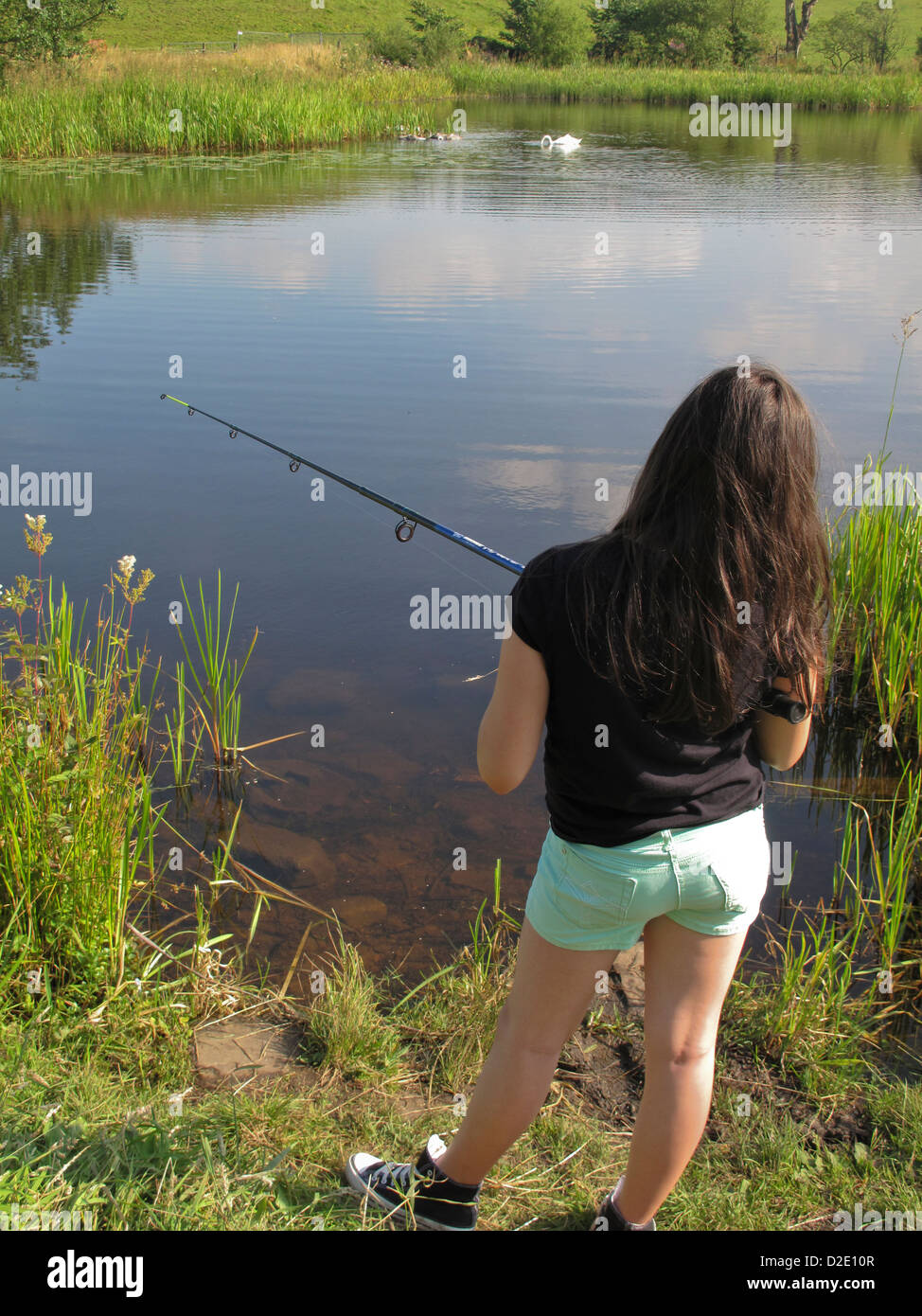Young girl angler fishing on canal Stock Photo - Alamy