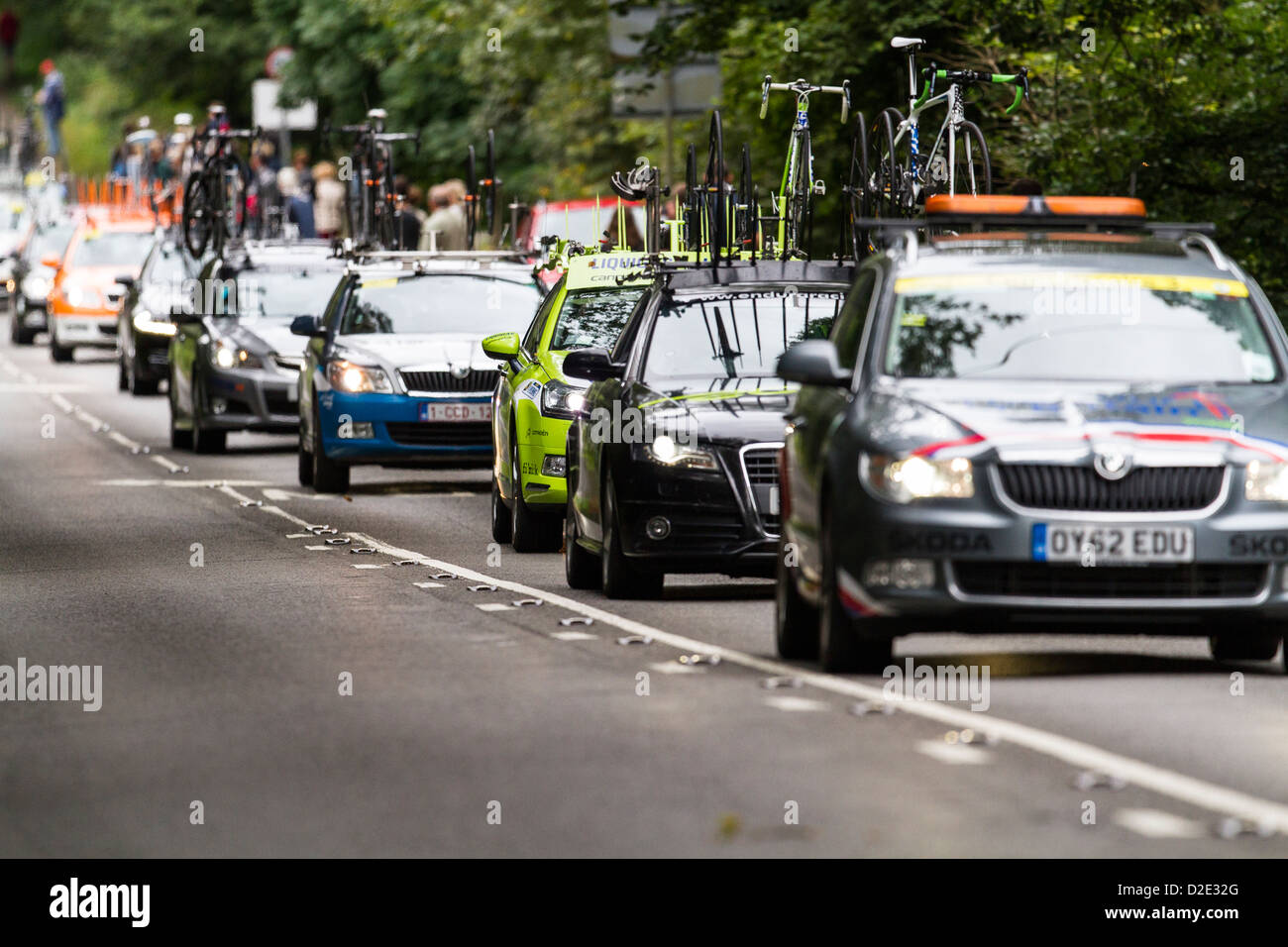 Team cars with roof mounted cycles queue behind the peloton on stage 8 ...