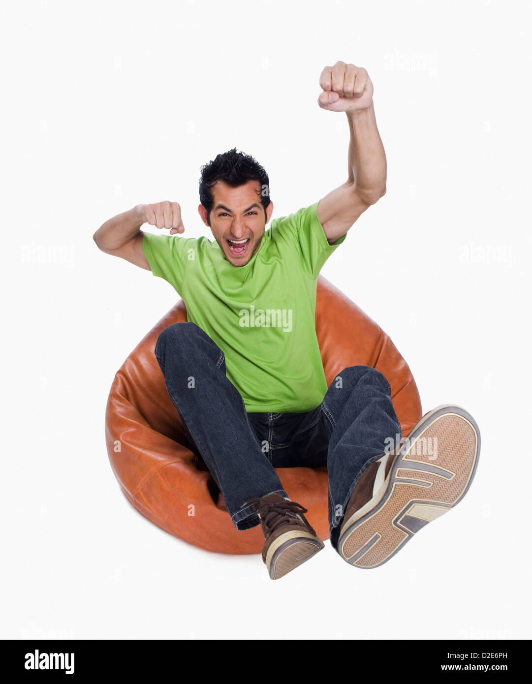 Portrait of a man cheering on a bean bag Stock Photo - Alamy