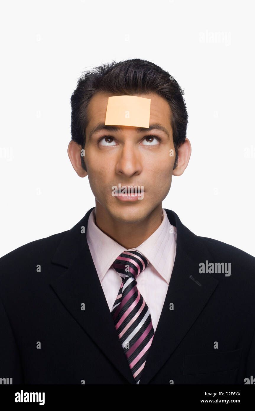 Businessman looking at a sticky note on his forehead Stock Photo - Alamy