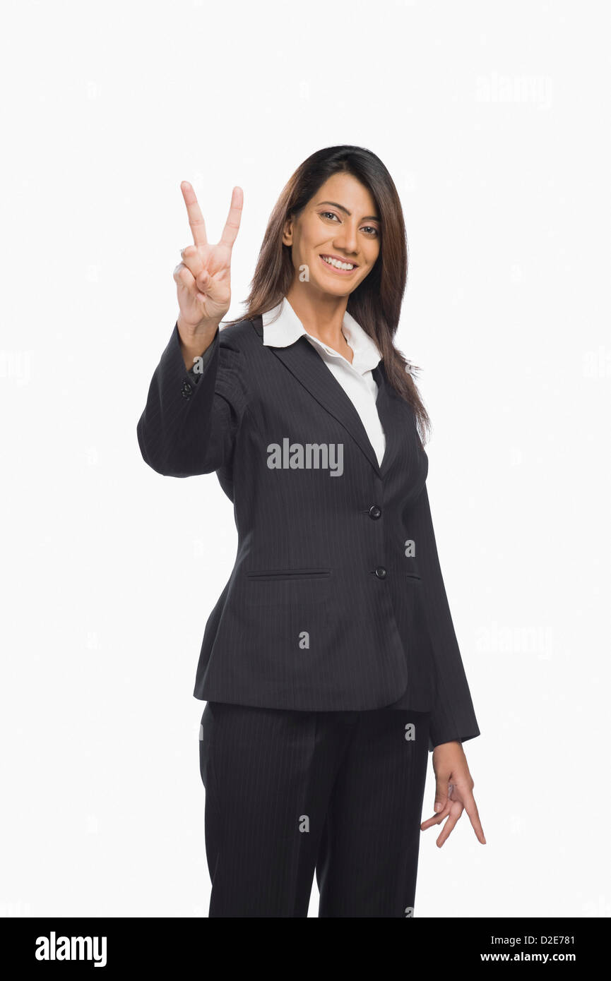 Portrait of a businesswoman gesturing victory sign Stock Photo - Alamy
