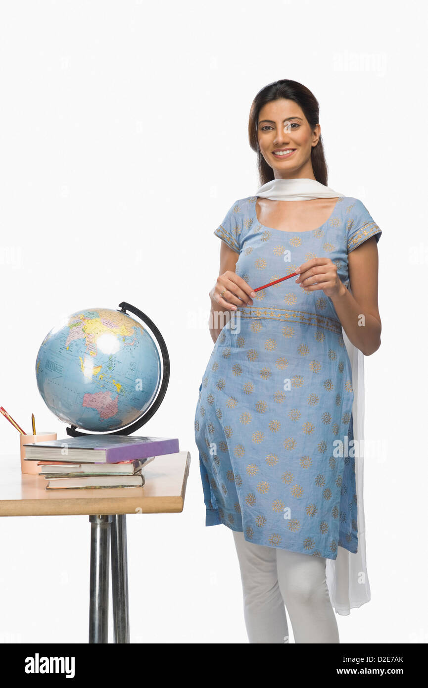 Female teacher holding a pen and smiling Stock Photo - Alamy