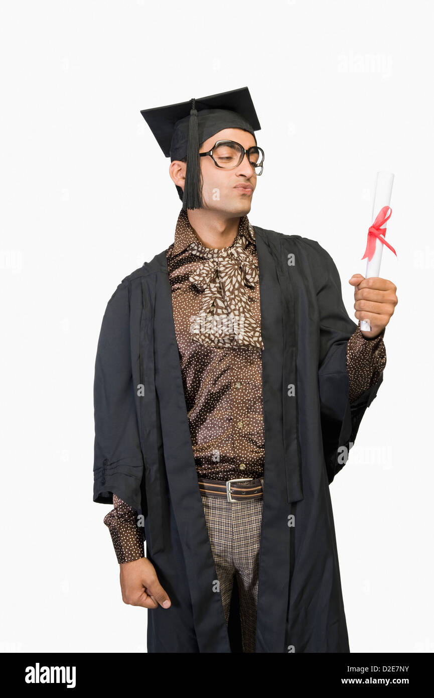 Man in a graduation gown holding a diploma Stock Photo - Alamy