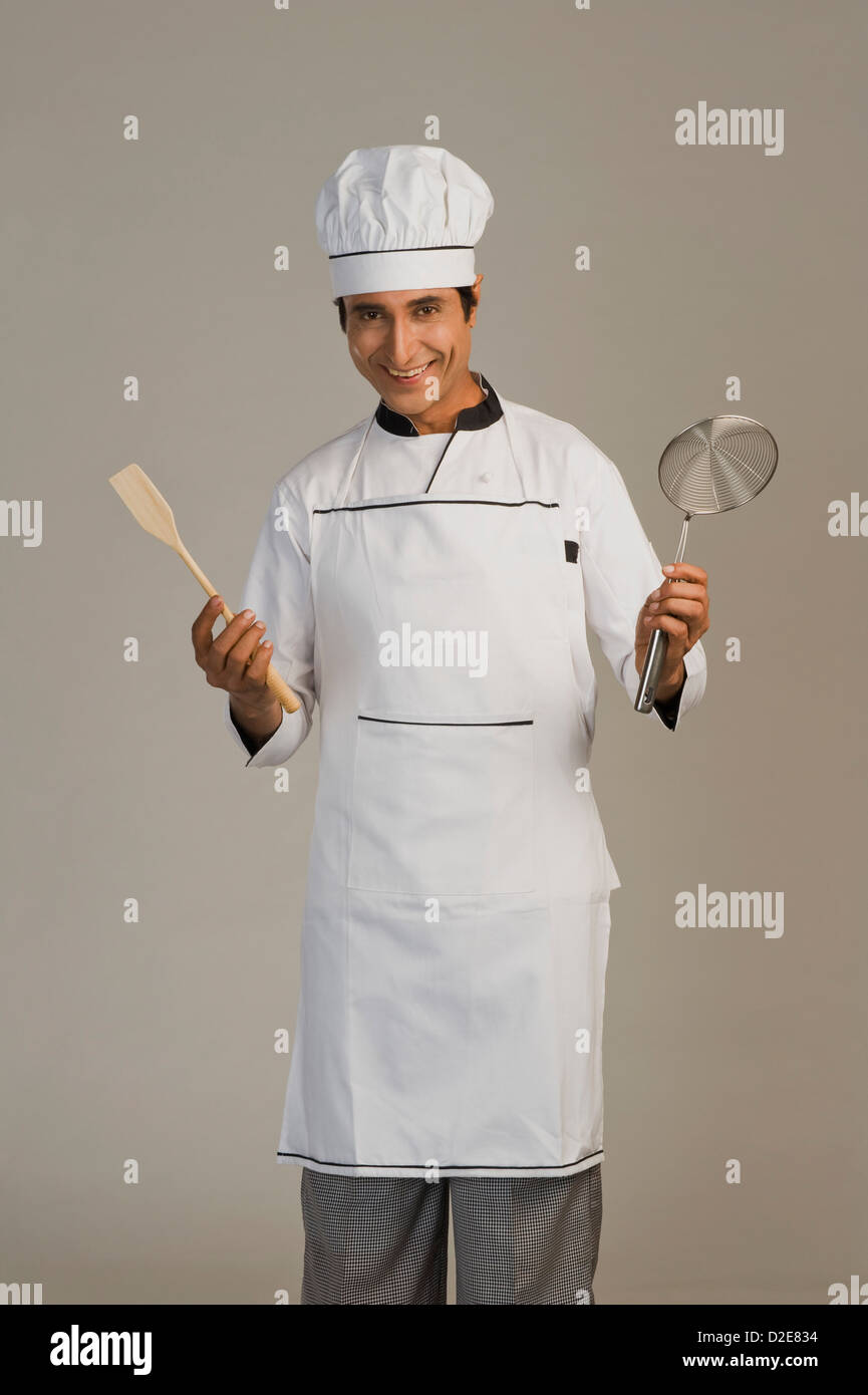 Portrait of a chef holding a sieve and a wooden spoon Stock Photo - Alamy