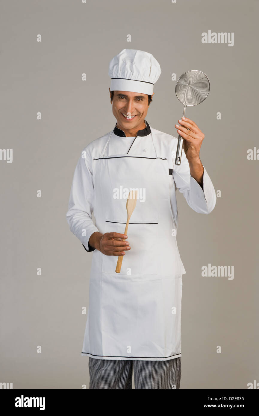 Portrait of a chef holding a sieve and a wooden spoon Stock Photo - Alamy