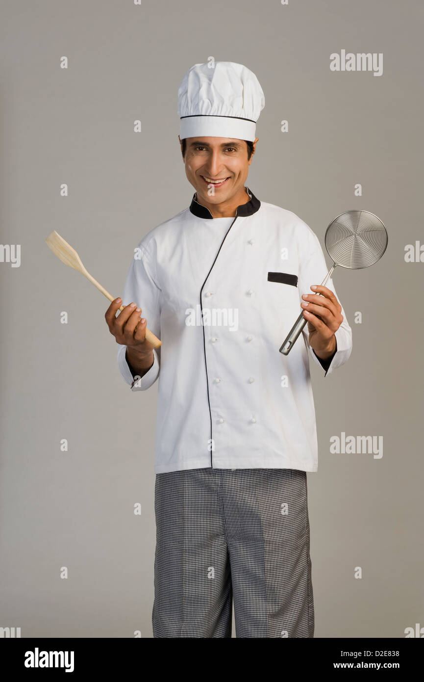 Portrait of a chef holding a sieve and a wooden spoon Stock Photo - Alamy