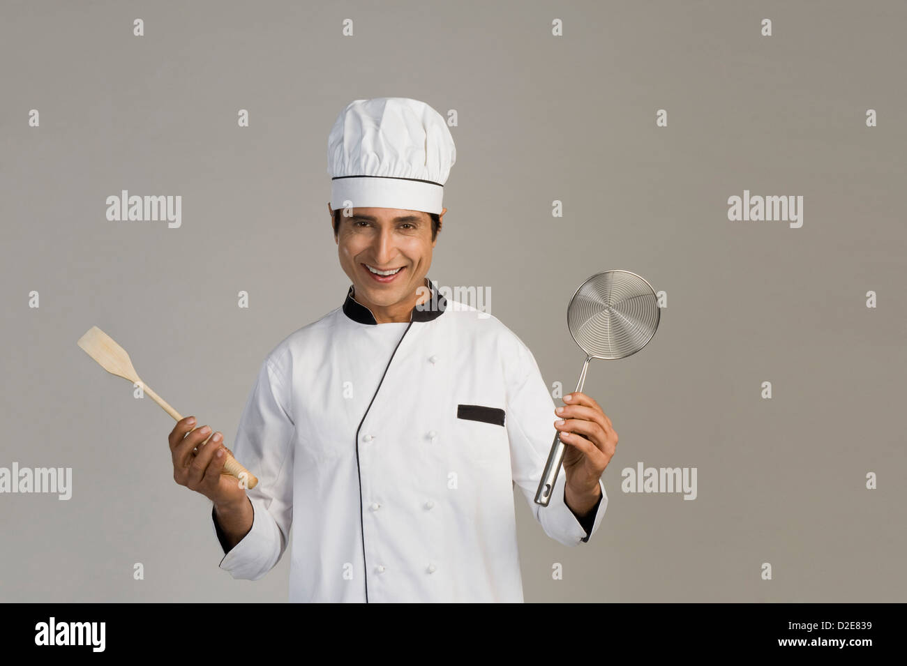 Portrait of a chef holding a sieve and a wooden spoon Stock Photo - Alamy