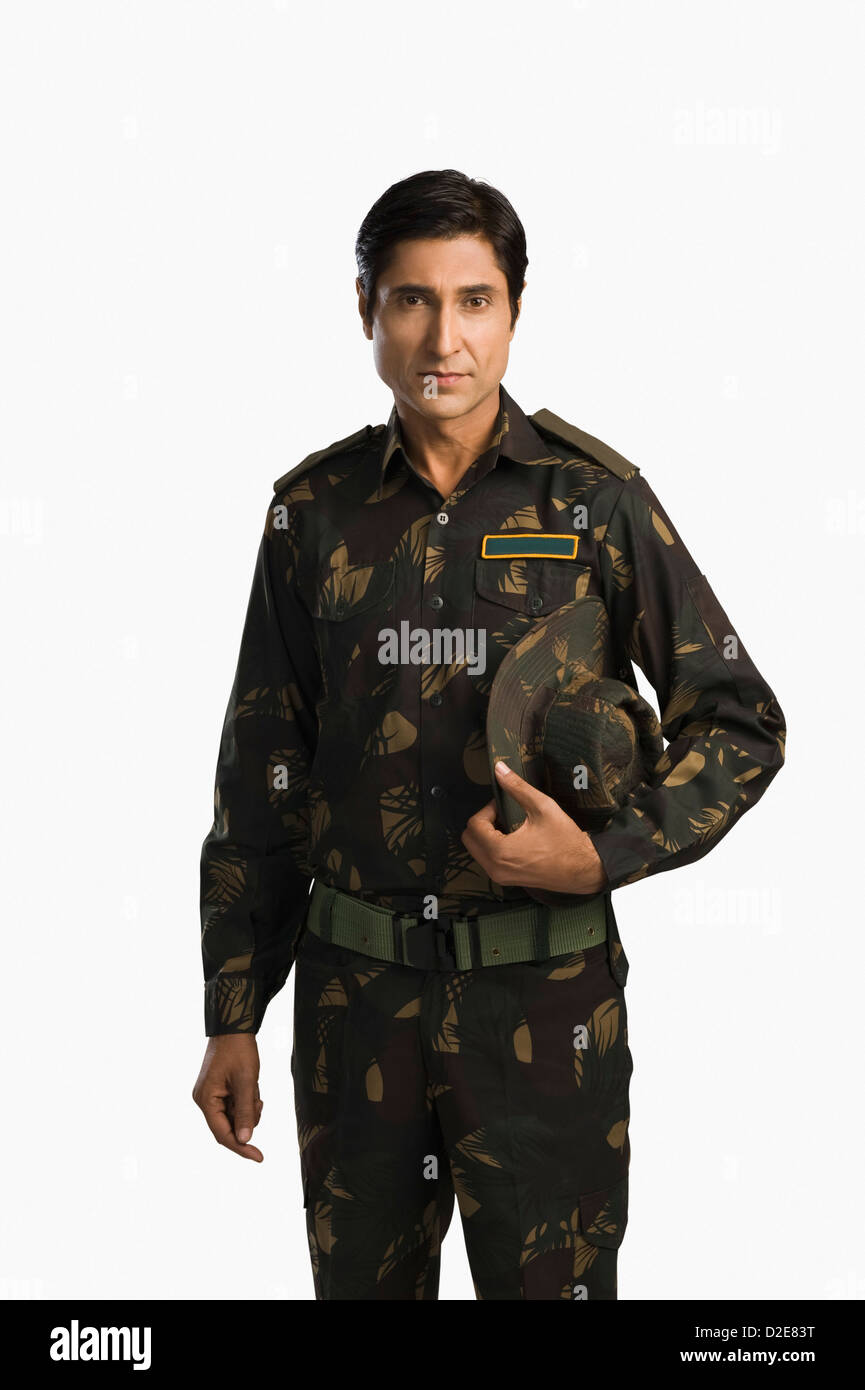 Portrait of an army soldier holding a cap Stock Photo - Alamy