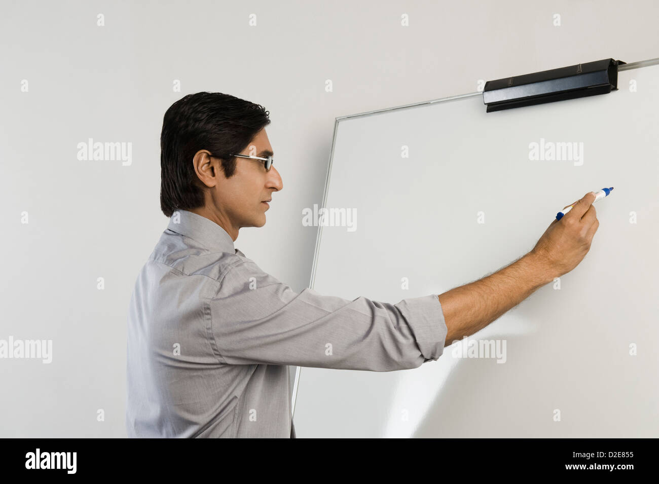 Teacher writing on a whiteboard Stock Photo - Alamy