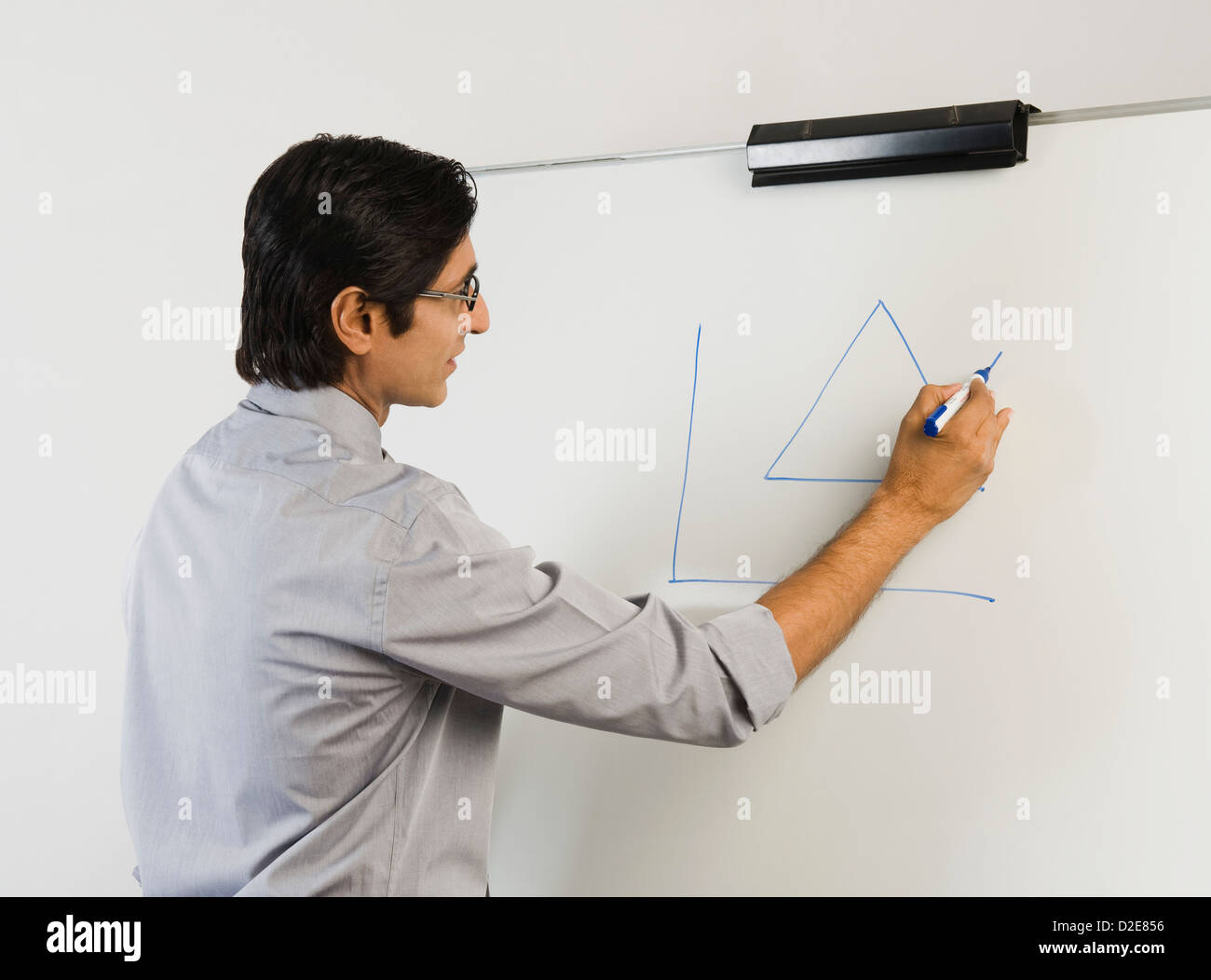Teacher writing on a whiteboard Stock Photo - Alamy