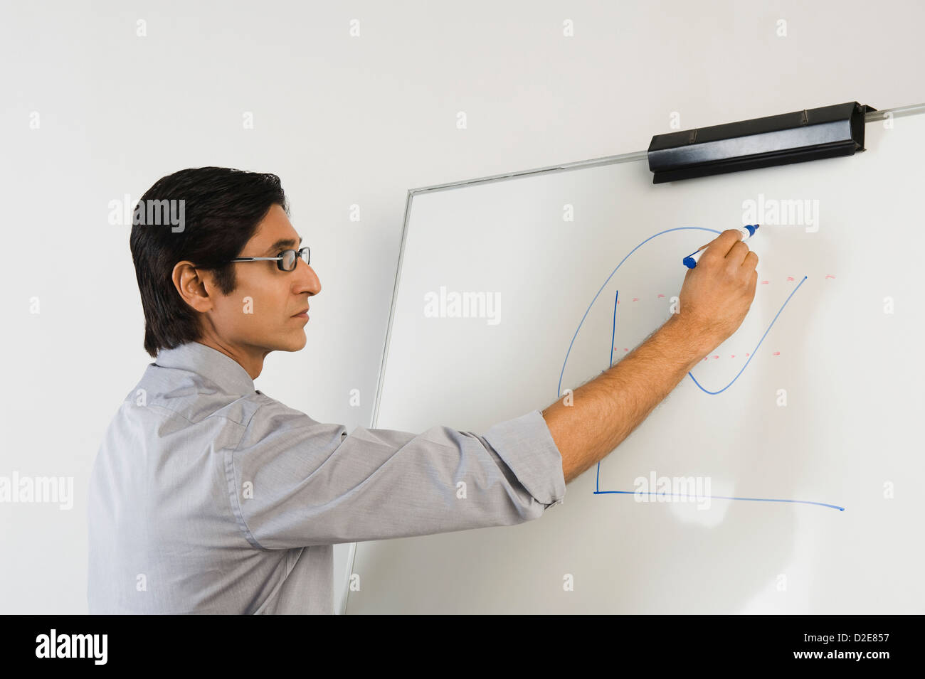 Teacher writing on a whiteboard Stock Photo - Alamy