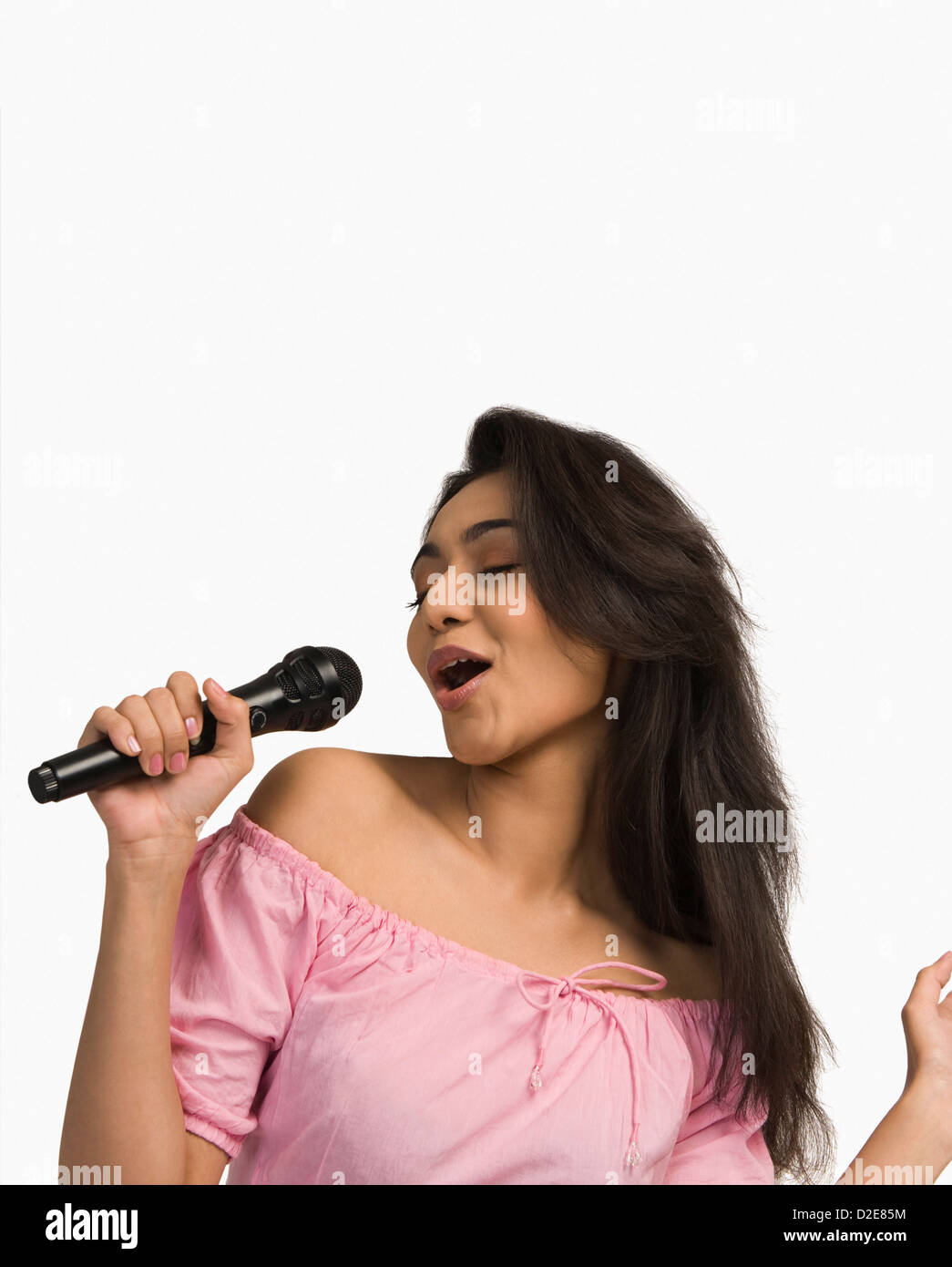 Woman singing into a microphone Stock Photo - Alamy