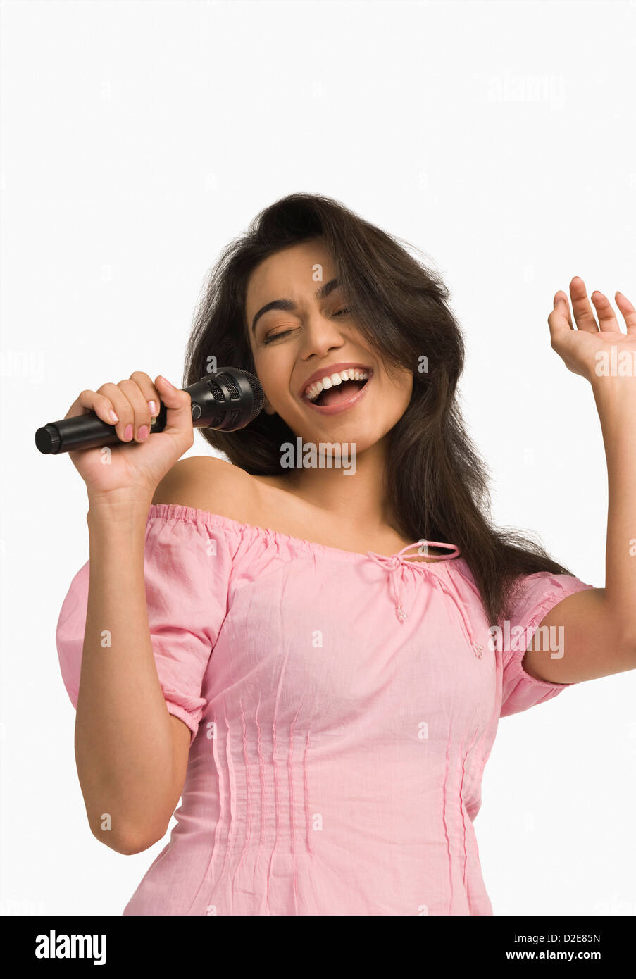 Woman singing into a microphone Stock Photo - Alamy