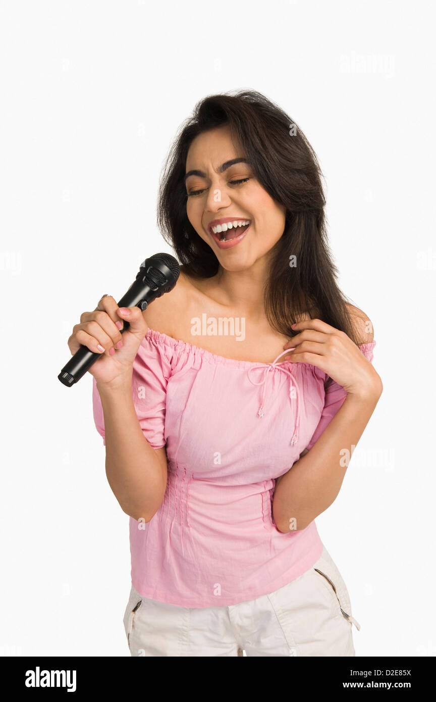 Woman singing into a microphone Stock Photo - Alamy