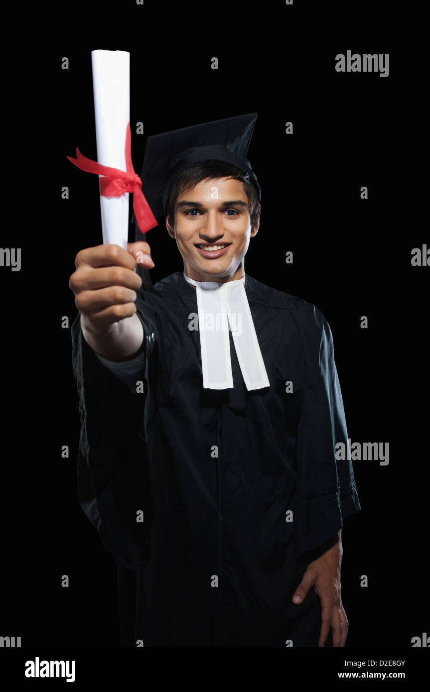 Portrait of a man in a graduation gown holding a diploma Stock Photo ...
