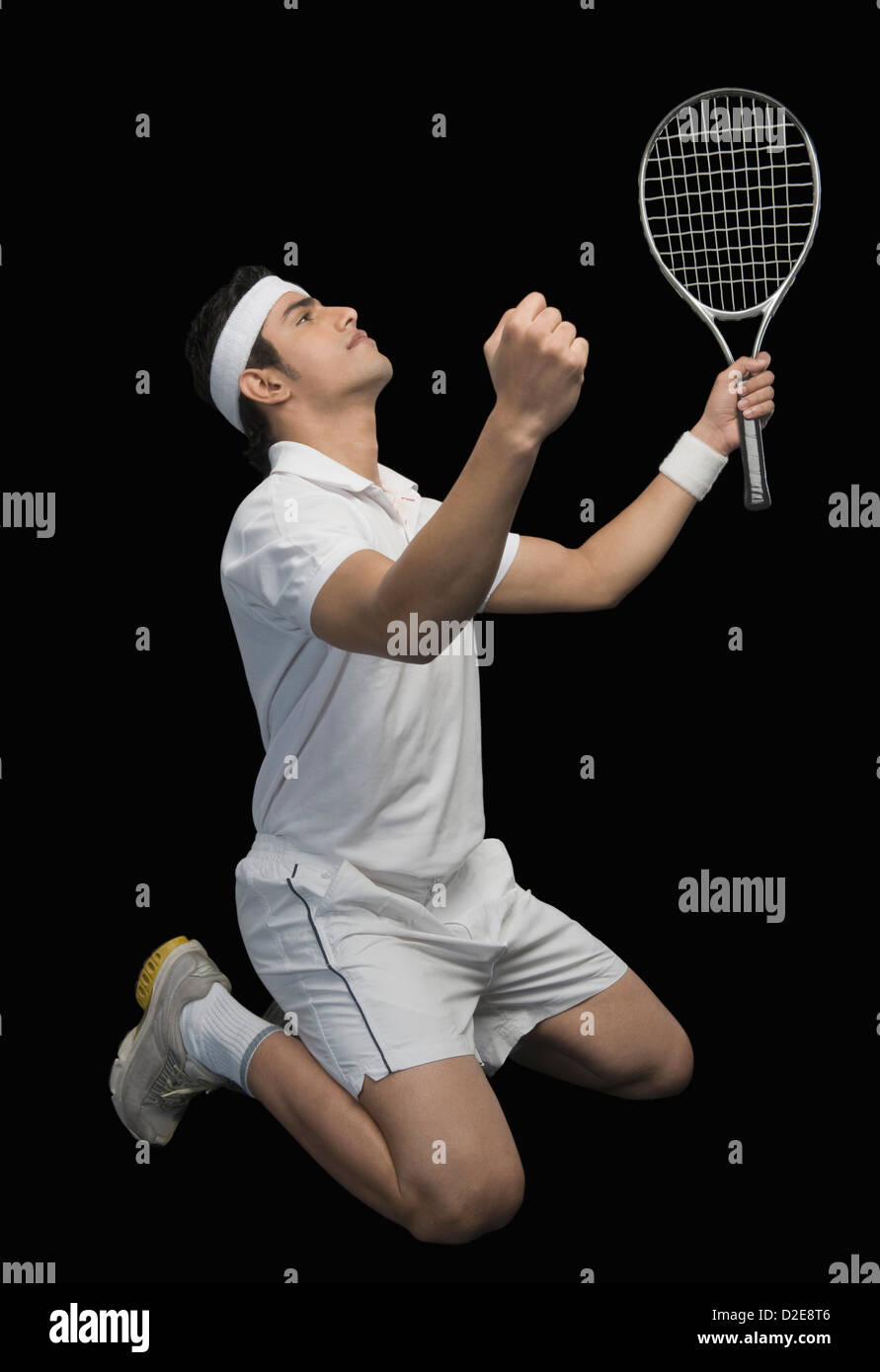 Tennis player celebrating with his arms raised Stock Photo - Alamy