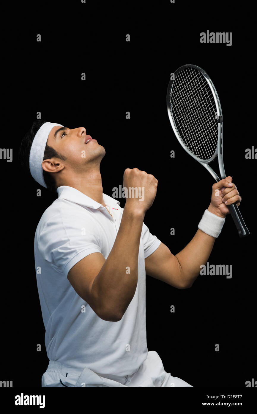Tennis player celebrating with his arms raised Stock Photo - Alamy