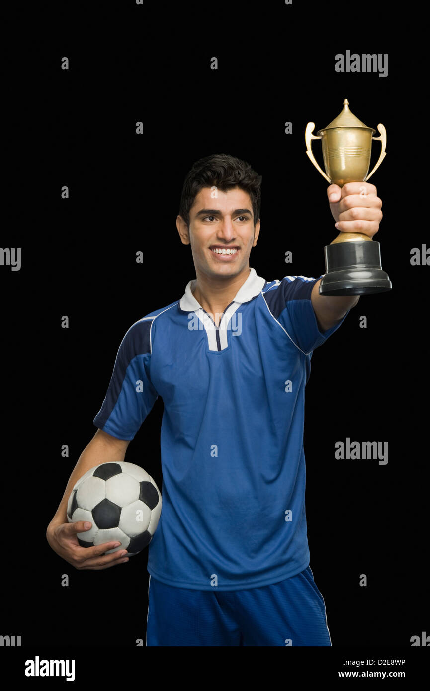 Holding trophy smiling looking away winning achievement hi-res stock ...