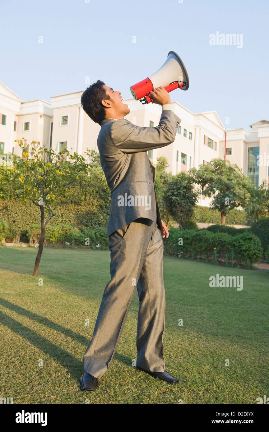 Businessman shouting into a megaphone Stock Photo - Alamy