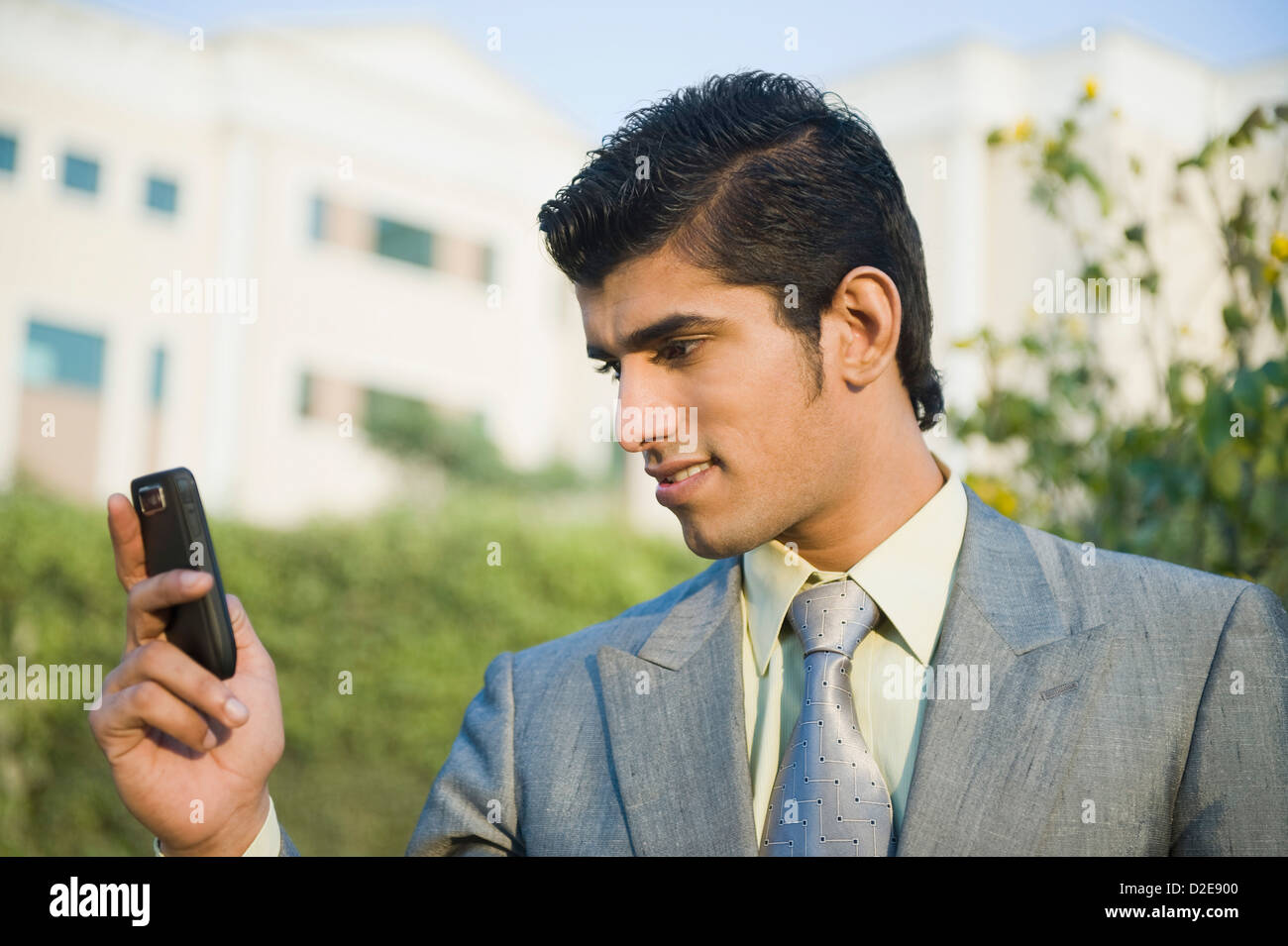 Businessman text messaging on a mobile phone Stock Photo - Alamy