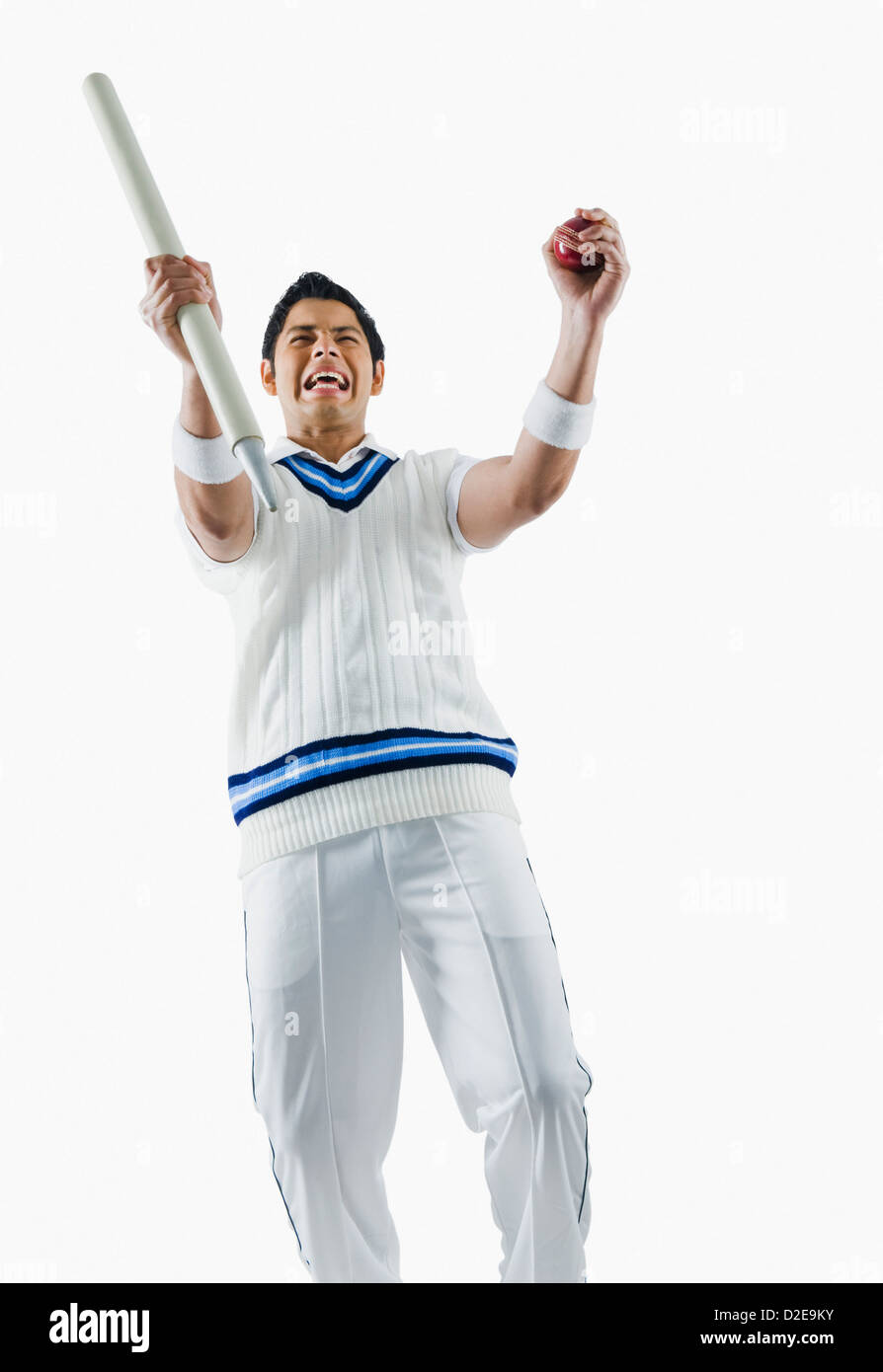 Cricket bowler cheering with a cricket ball and stump Stock Photo - Alamy
