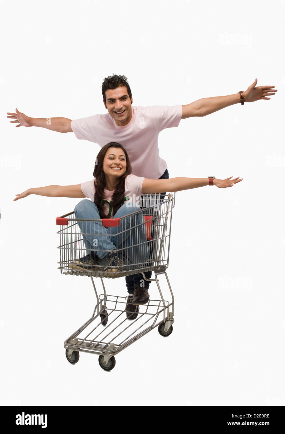 Man pushing a woman sitting in shopping cart Stock Photo - Alamy