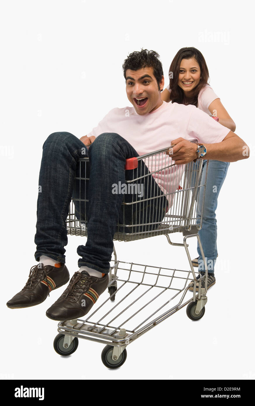 Woman pushing a man sitting in shopping cart Stock Photo - Alamy
