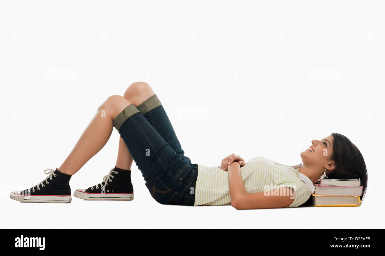 Female university student resting on a stack of books Stock Photo - Alamy