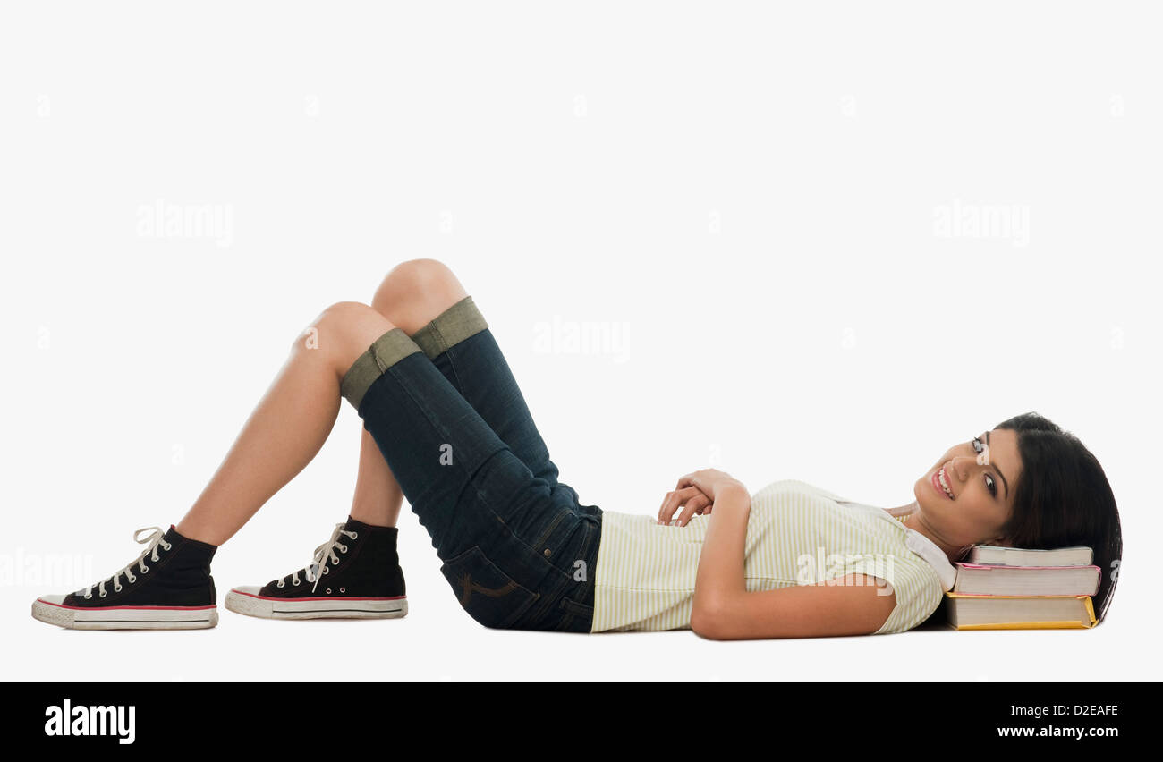 Female university student resting on a stack of books Stock Photo - Alamy