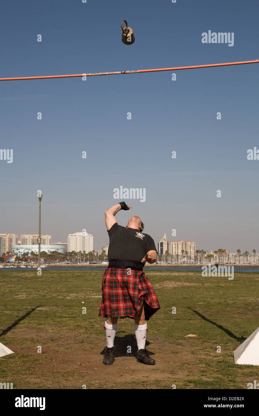 A man in a red kilt throws a weight over the bar at the Queen Mary ...