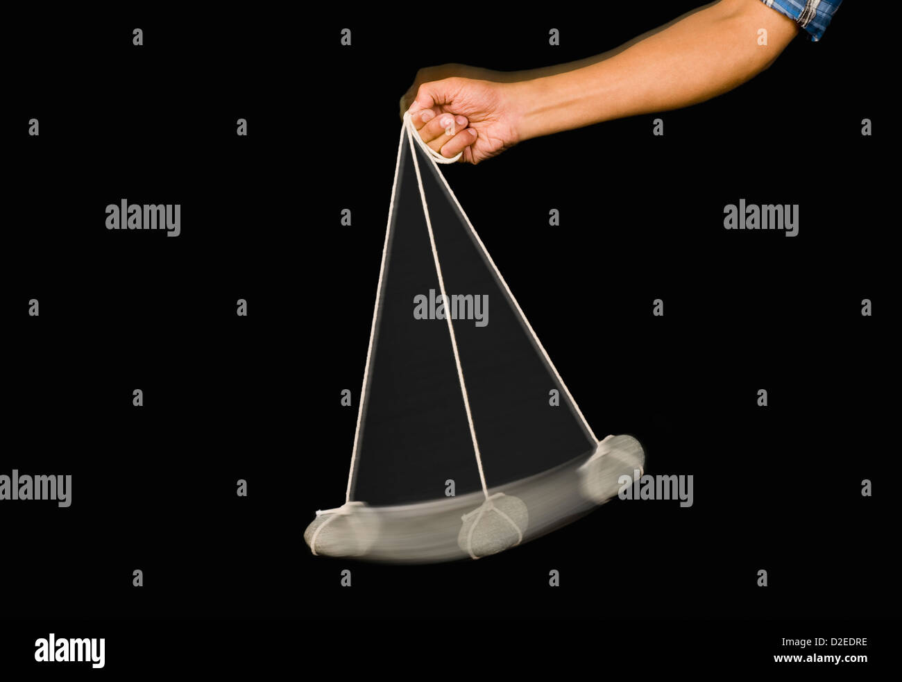 Close-up of a person's hand swinging a stone pendulum Stock Photo - Alamy