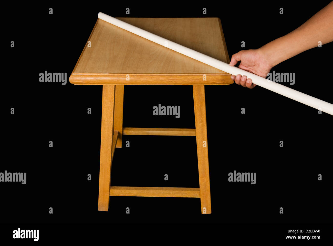 Close-up of man measuring a straight surface with a stick Stock Photo ...