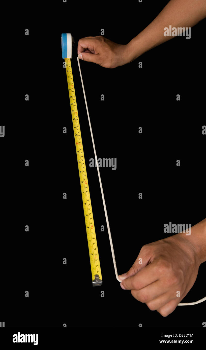 Close-up of a man measuring string with a tape measure Stock Photo - Alamy