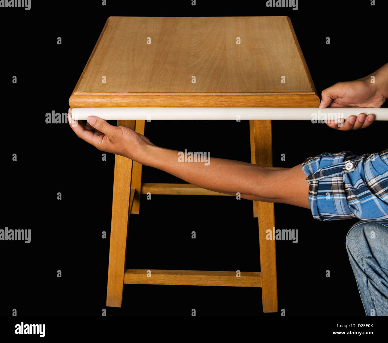 Close-up of a man measuring a surface with a stick Stock Photo - Alamy