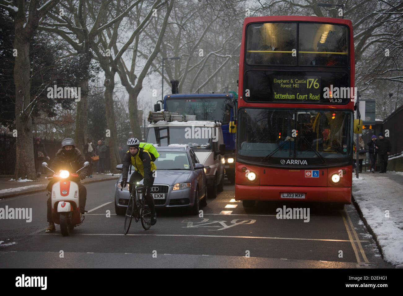 Drivers and cyclists share two lanes of a road junction in freezing mid ...