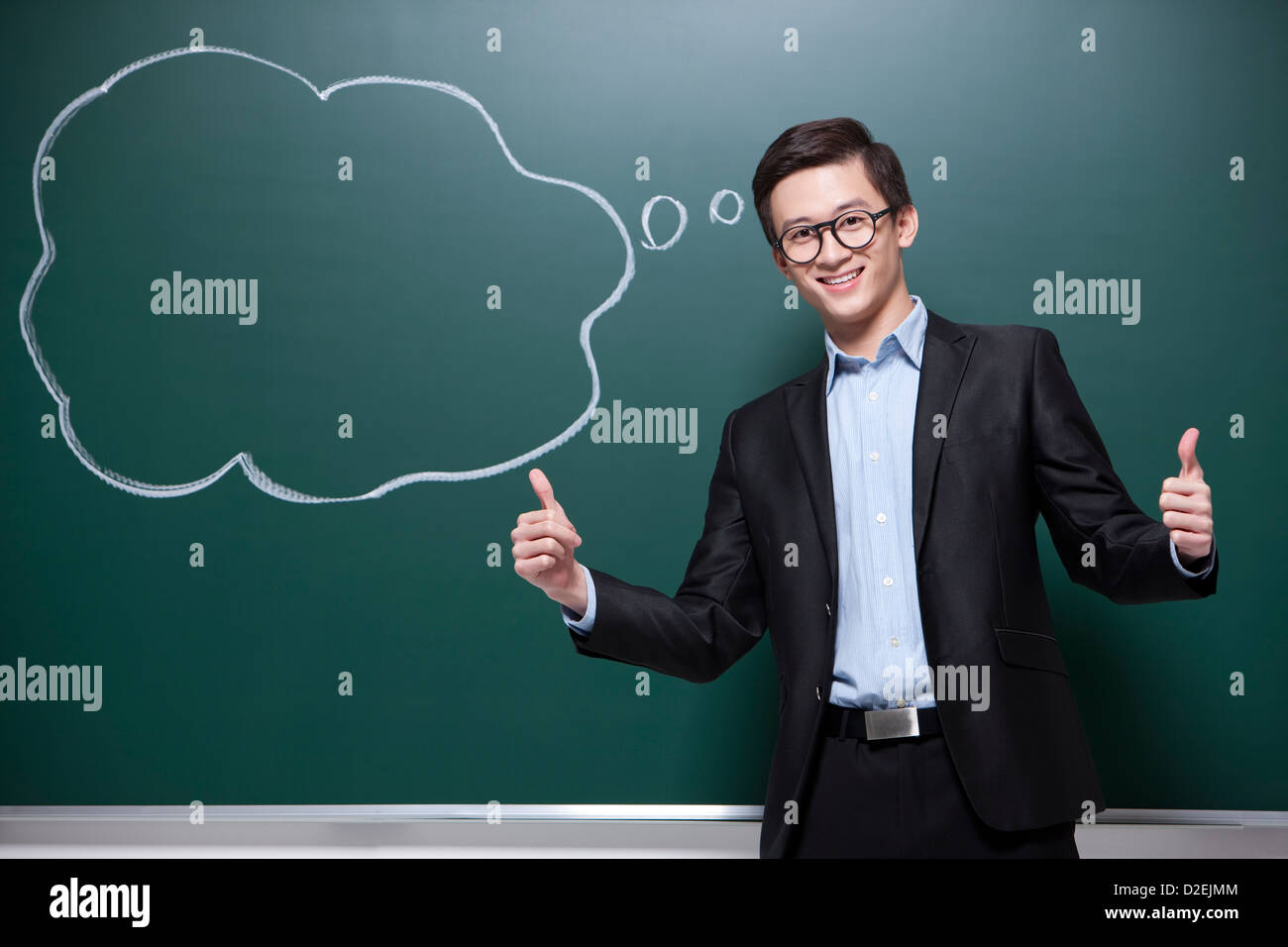Humorous male teacher doing thumbs up in classroom Stock Photo - Alamy