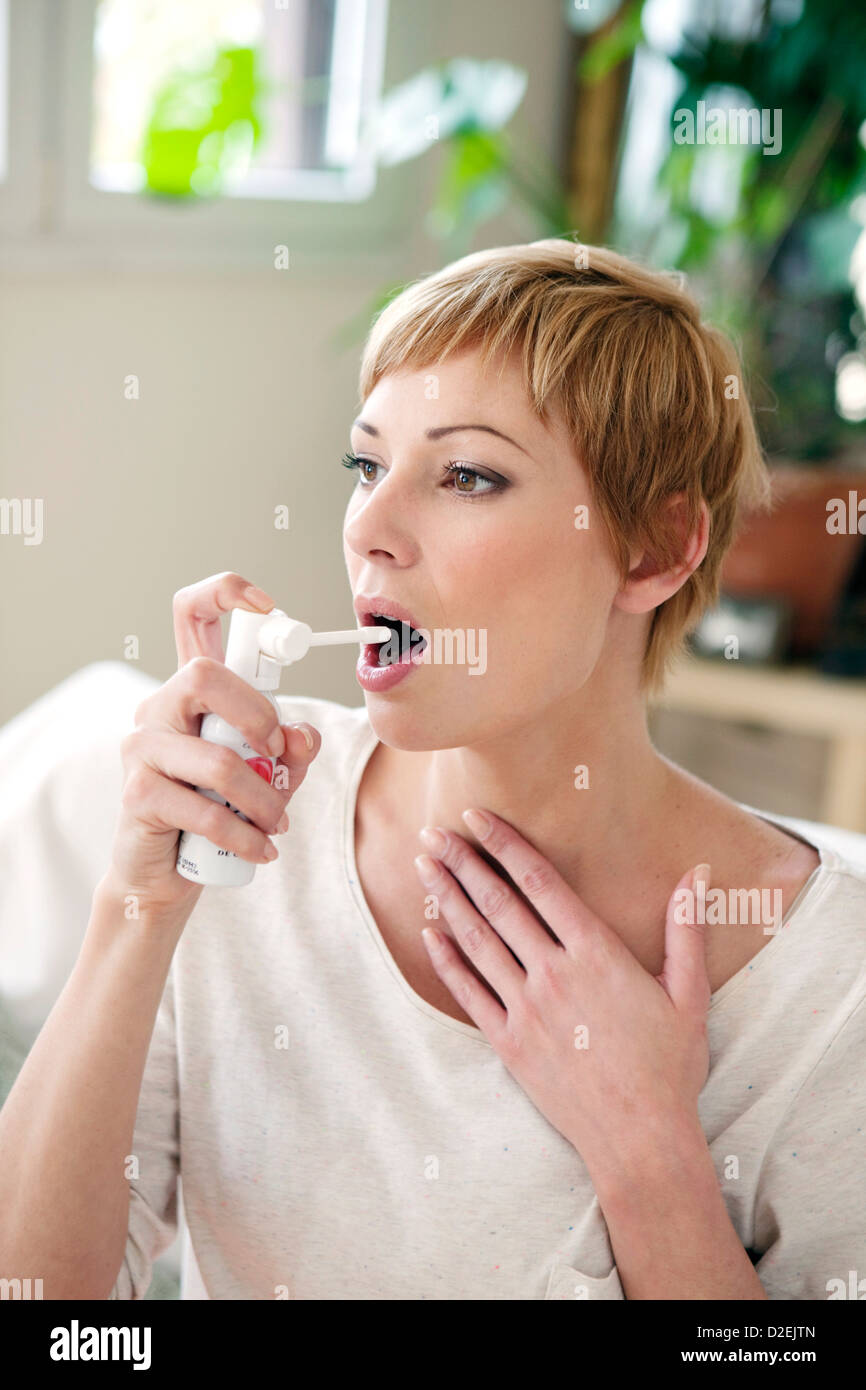 WOMAN USING SPRAY IN MOUTH Stock Photo - Alamy