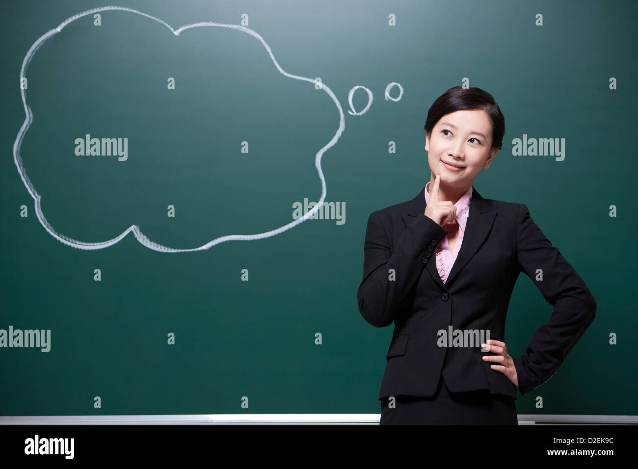 Professional female teacher hand on chin in classroom Stock Photo - Alamy