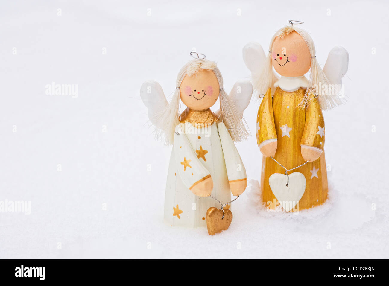 Two decorative wooden angels in the snow Stock Photo - Alamy