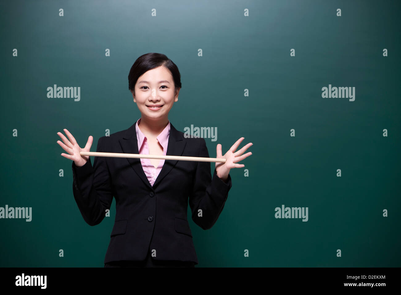 Happy female teacher holding teacher's pointer in classroom Stock Photo ...