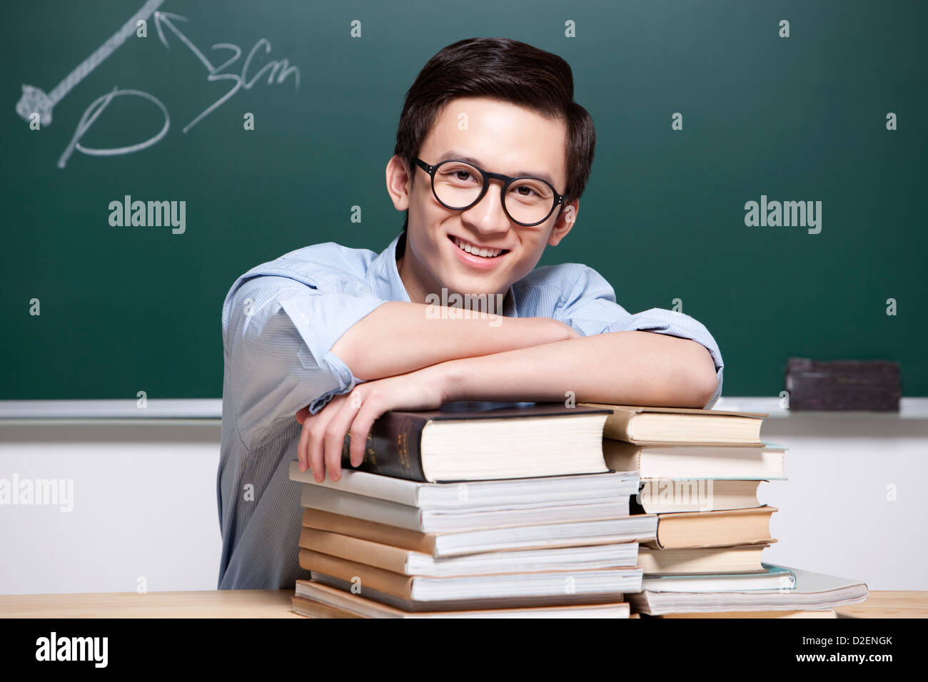 Happy male teacher with textbooks in classroom Stock Photo - Alamy