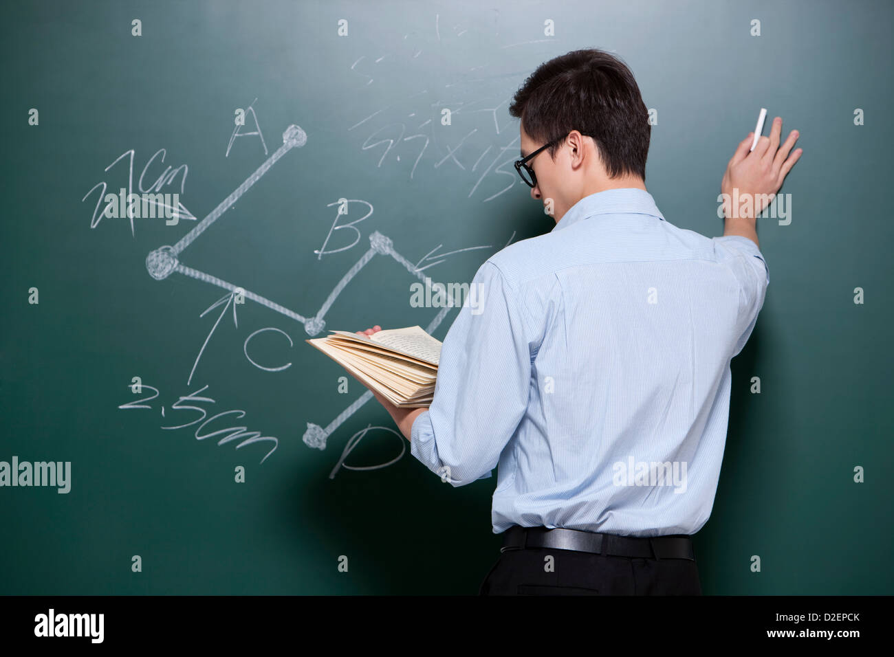 Professional male teacher writing on blackboard Stock Photo - Alamy