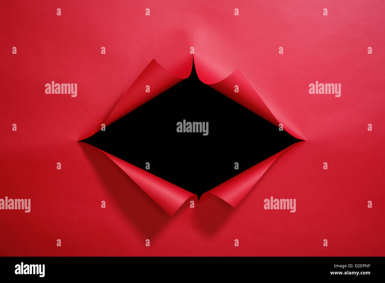 Hole in red wrapping paper Stock Photo - Alamy