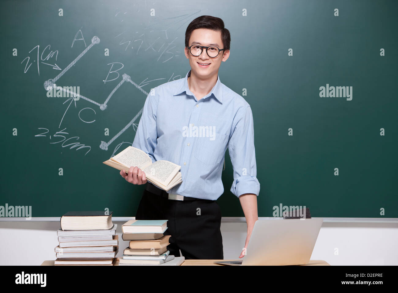 Professional male teacher using laptop in classroom Stock Photo - Alamy