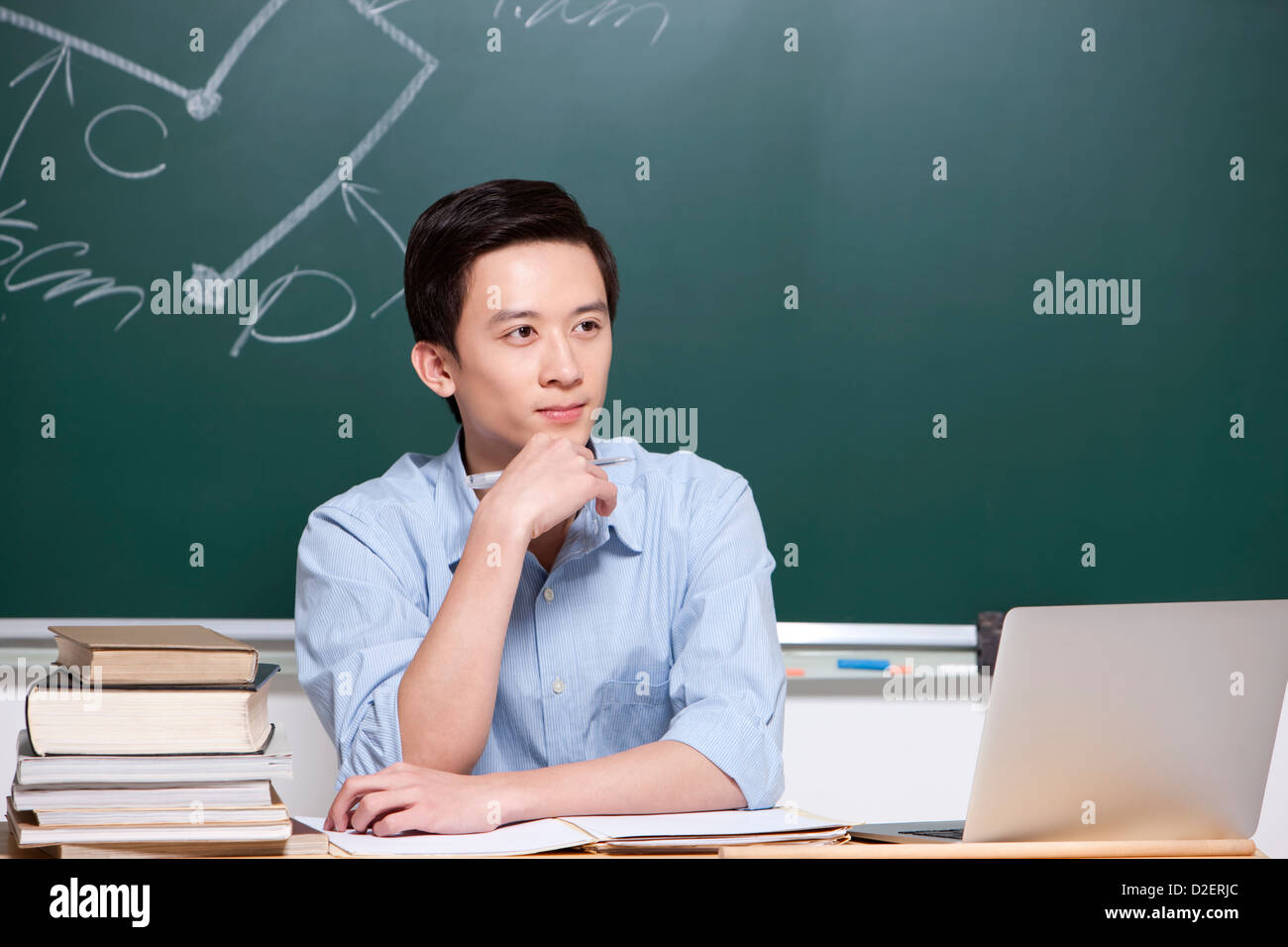 Serious male teacher hand on chin in classroom Stock Photo - Alamy