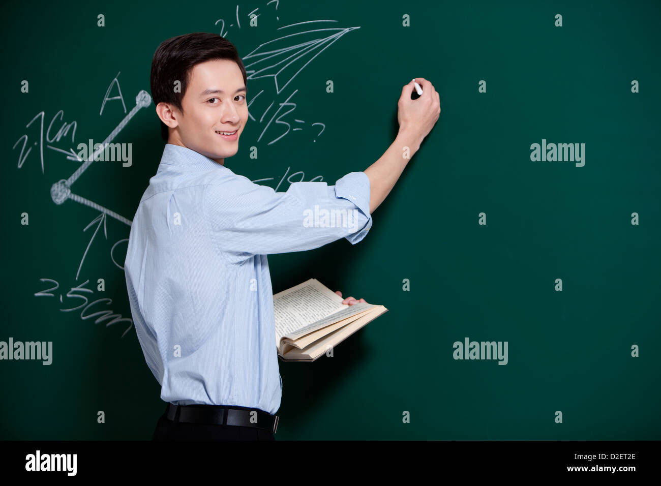 Professional male teacher writing on blackboard Stock Photo - Alamy