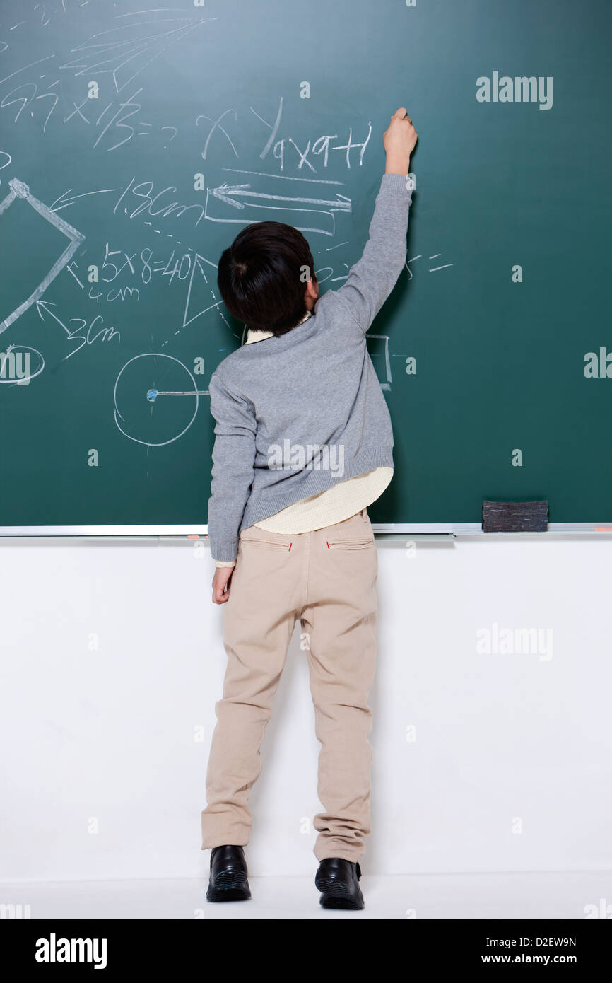 Happy little boy writing on blackboard Stock Photo - Alamy