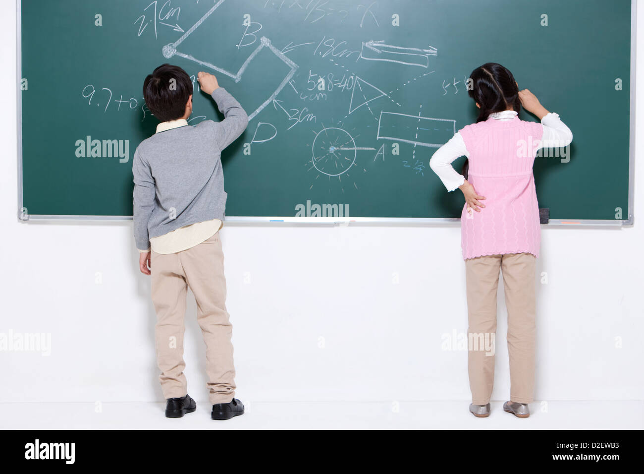 Elementary schoolchildren writing on blackboard in classroom Stock ...